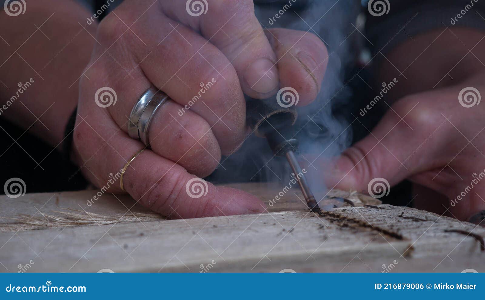 Close-up of Worker`s Hand with Tools Hacking Wood with Smoke that is ...
