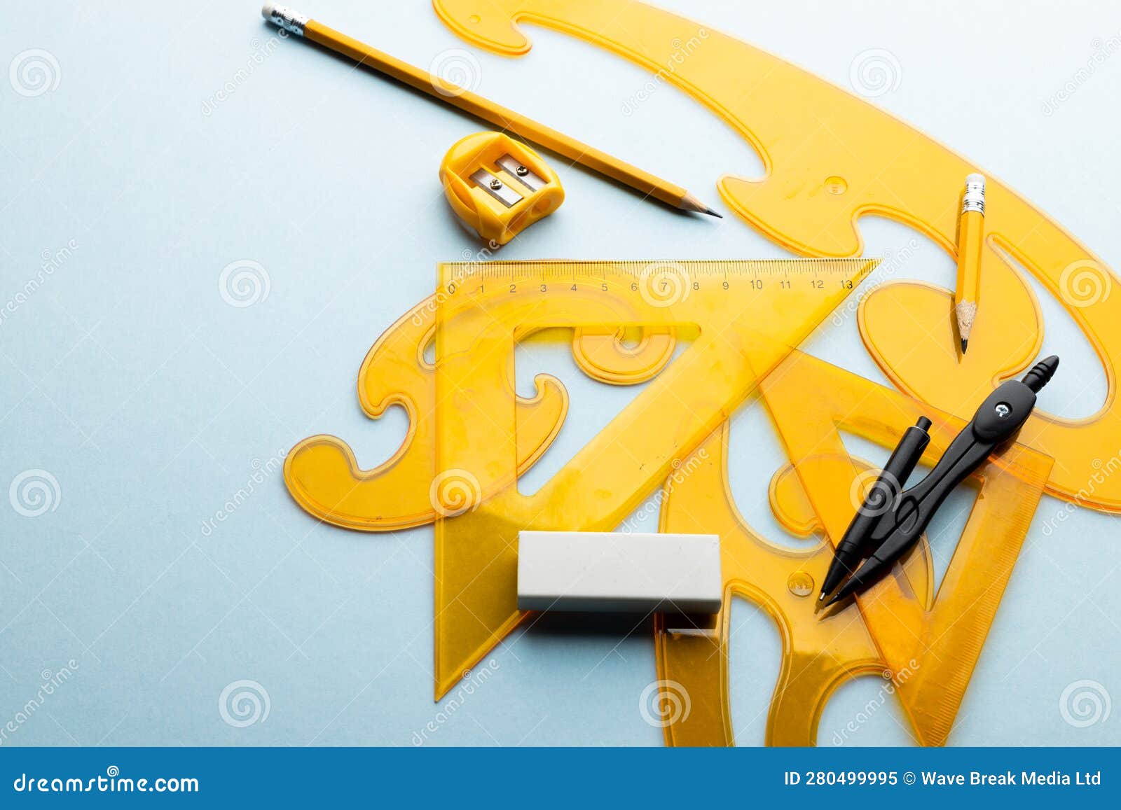 Close Up of Yellow Rulers, Compass and Sharpener on Blue Background ...