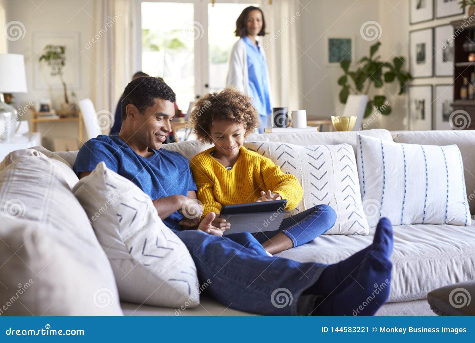 Close Up Of Young Father Sitting On Sofa In The Living Room With His