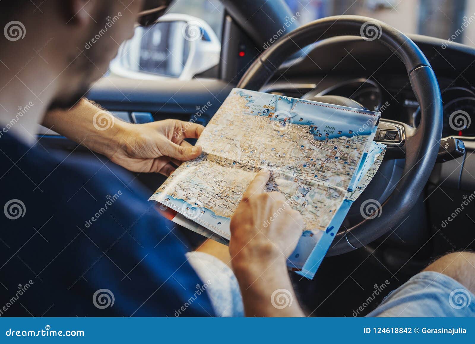 Close Up of Young Man Looking at Map Behind the Wheel in Car. Stock ...