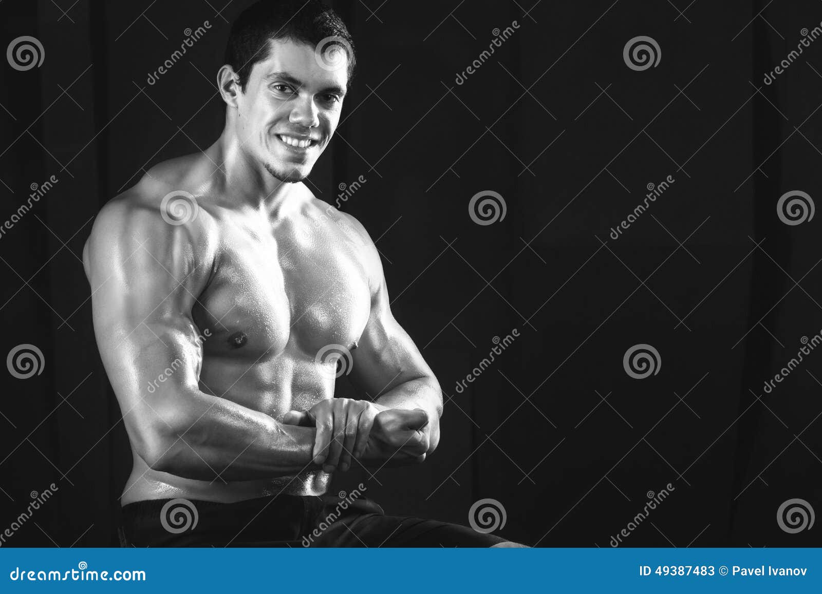 Close Up of Young Muscular Man Lifting Weights Over Dark Stock Image ...