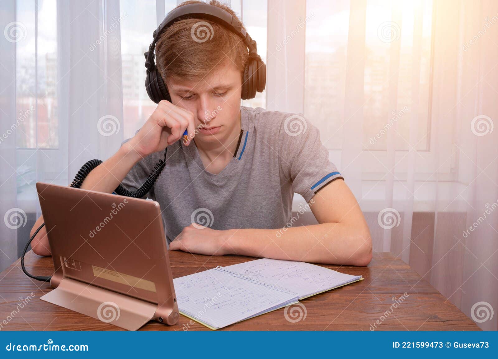 Close-up of a Young Student Wearing Headphones, Using a Laptop Computer ...