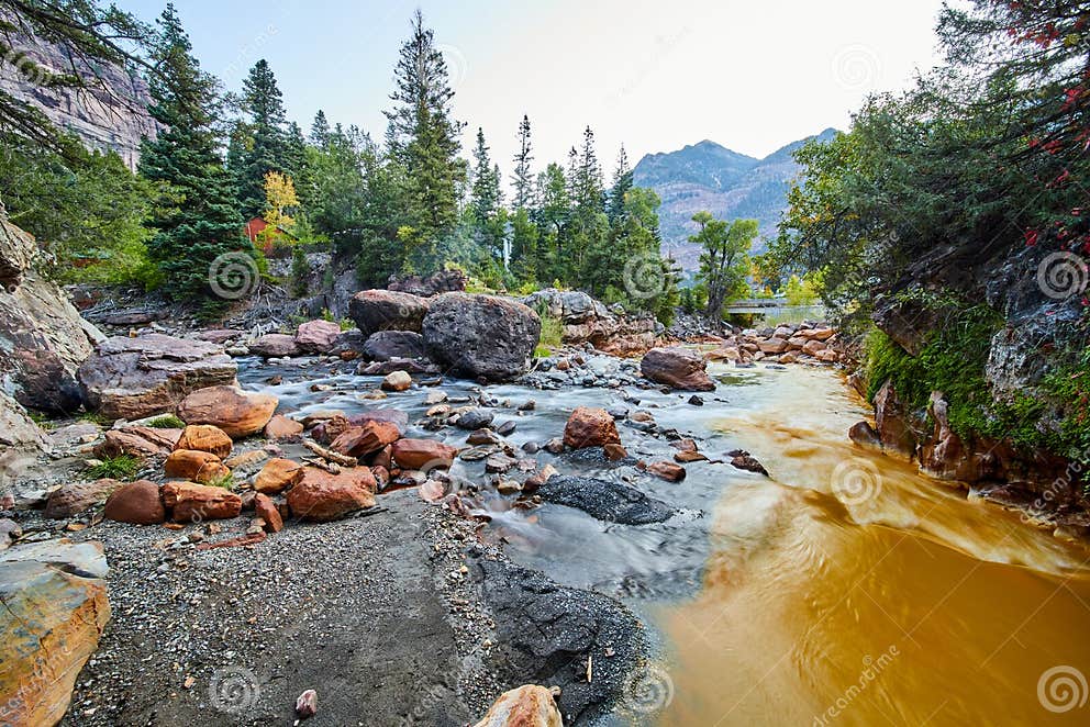 Close View of Red Rocks at River Intersection with Mountains in ...