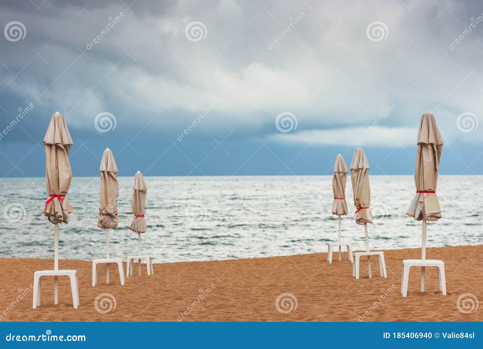 Closed Beach Umbrellas, Sand, Sea and Stormy Clouds Stock Photo - Image ...