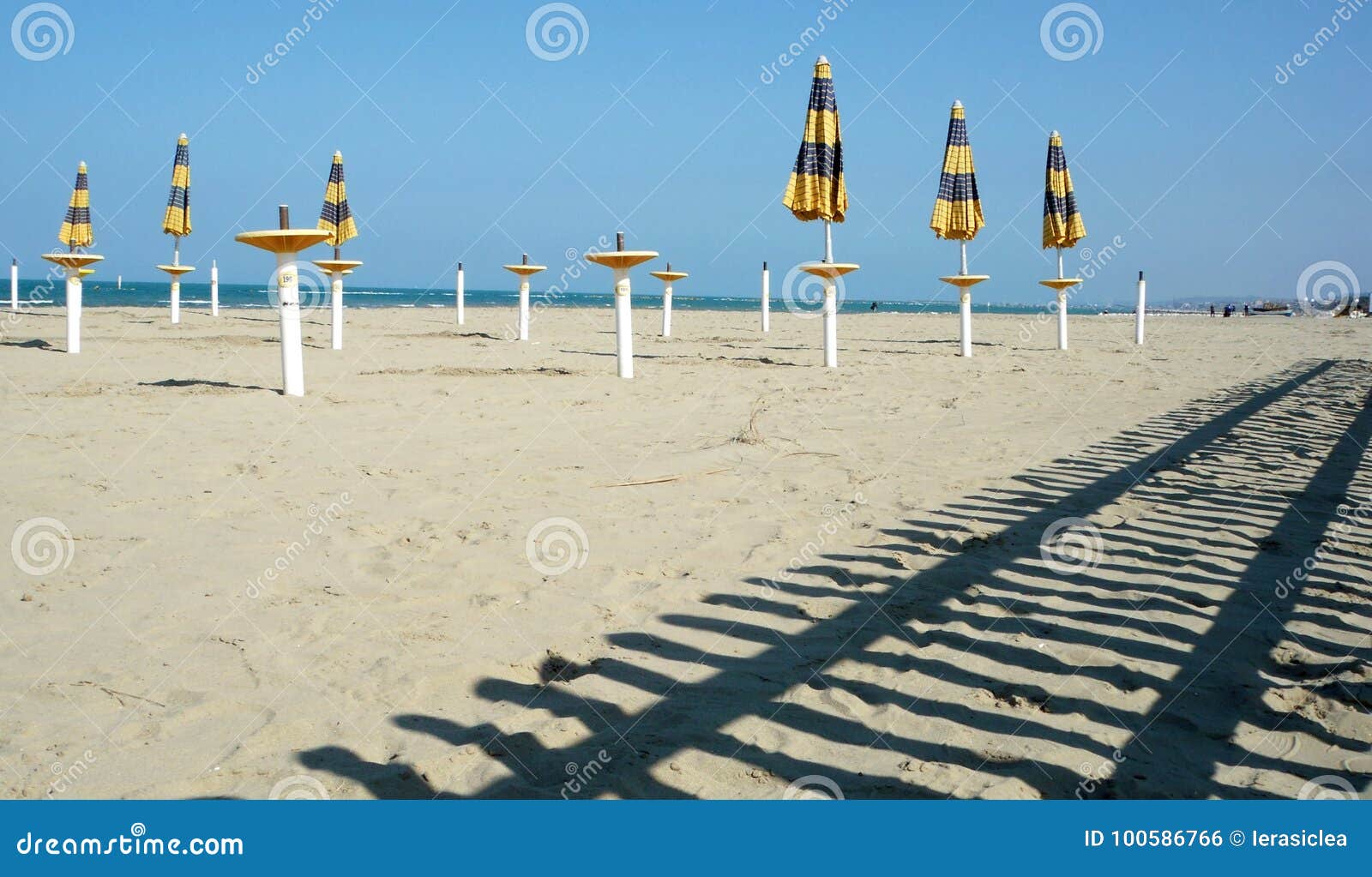Closed Parasol and Shadow on the Beach Stock Photo - Image of beautiful ...