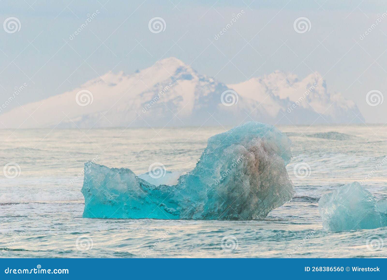 Closeup of a Big Ice on the Water with Snowy Mountains in the ...