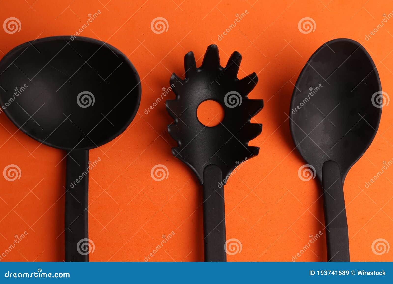 Closeup of Black Kitchen Utensils on Orange Background Stock Image ...
