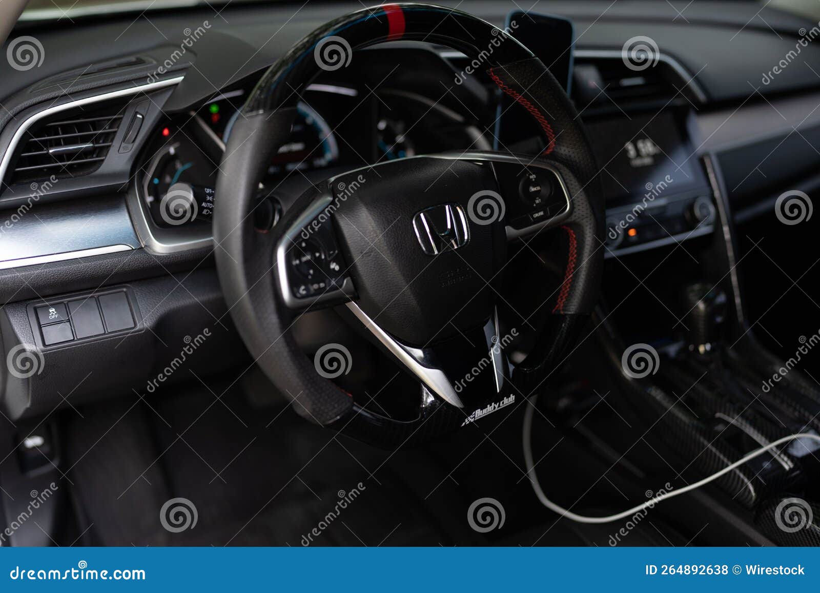 Closeup of the Black Steering Wheel with Red Lines and the Silver Logo ...