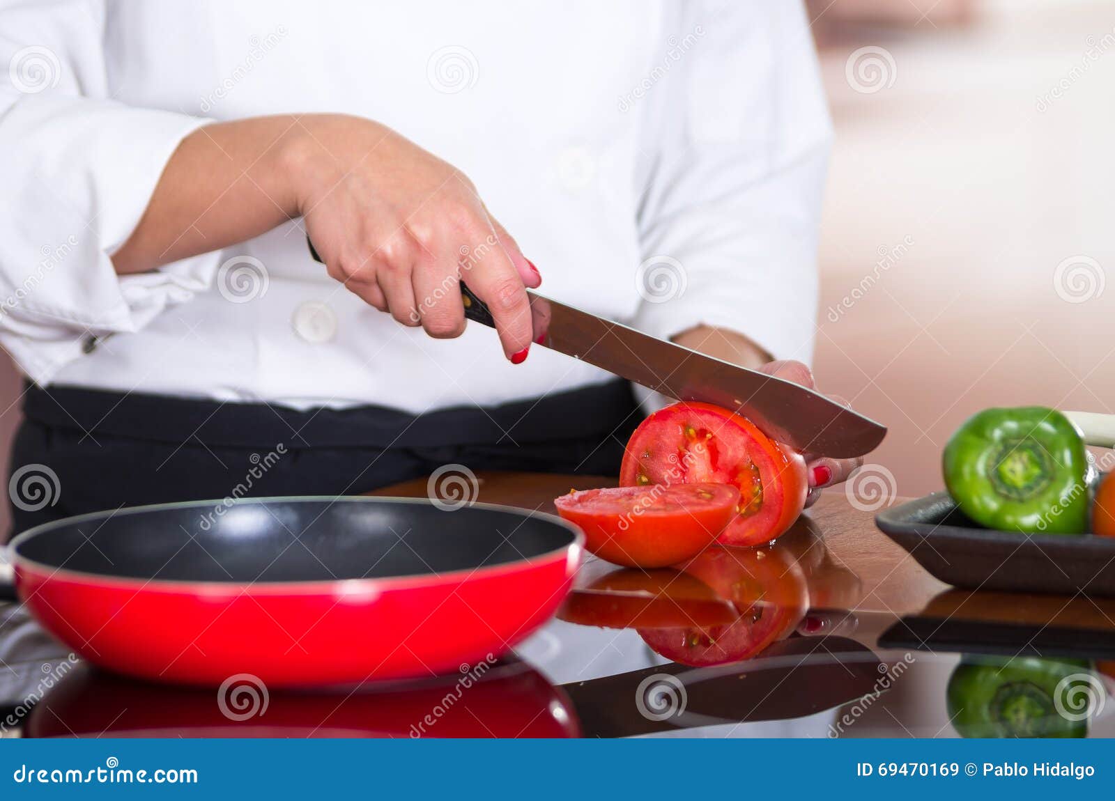 Closeup Chef Cutting Tomato on Wooden Surface with Red Skillet in Front ...