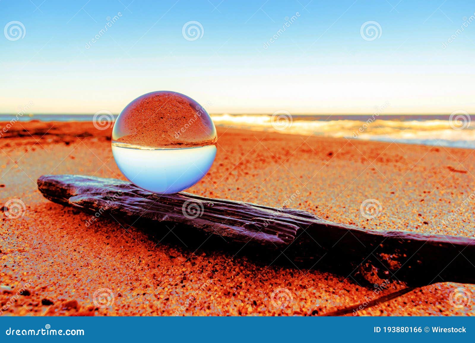 Closeup of a Crystal Ball on the Beach with the Surroundings Reflecting ...