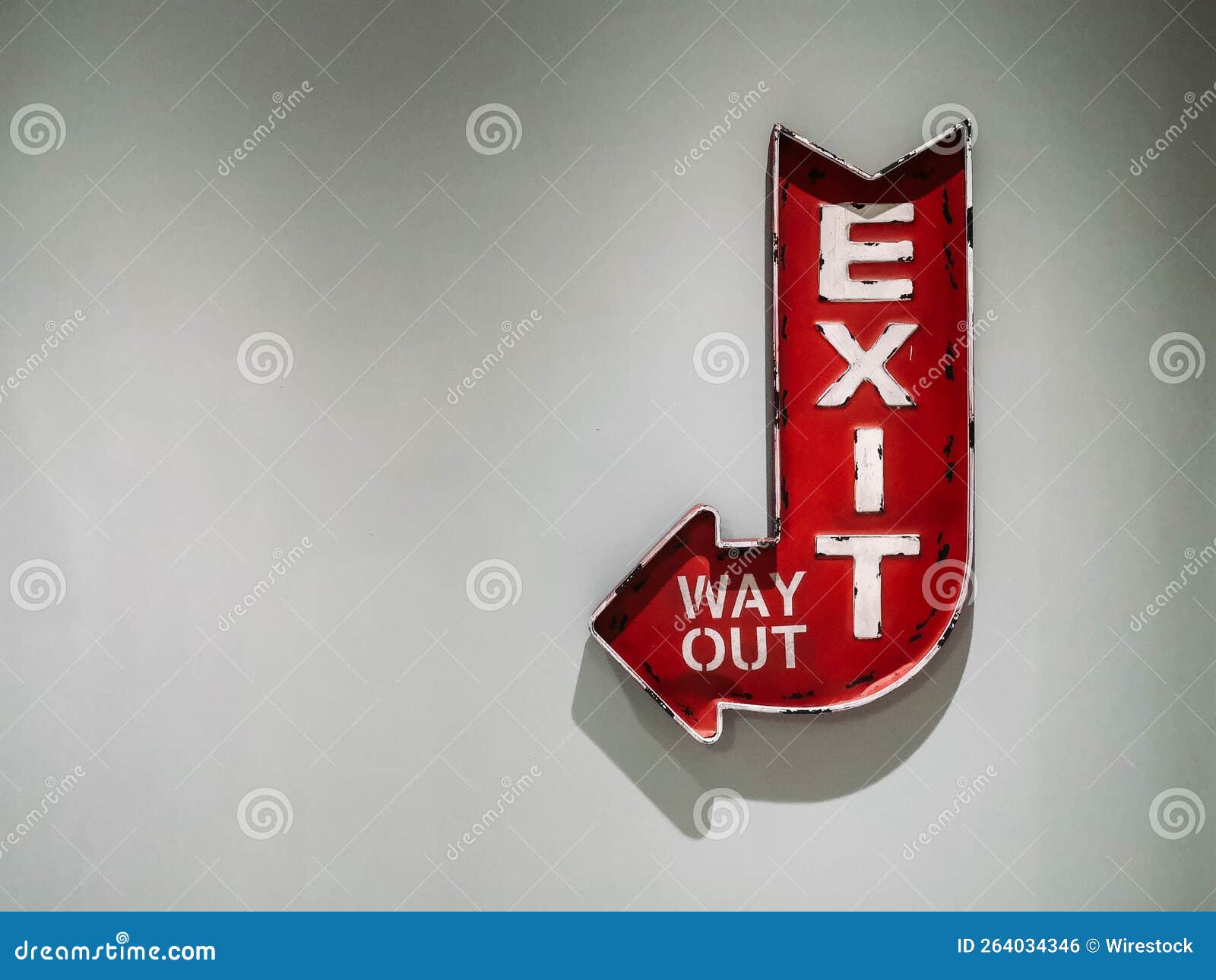 Closeup of an EXIT Sign with a Curvy Arrow on a Gray Wall Stock Photo ...