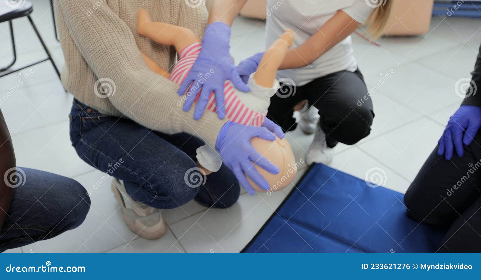 Closeup of First Aid Instructor Using Infant Dummy Demonstrating How To ...