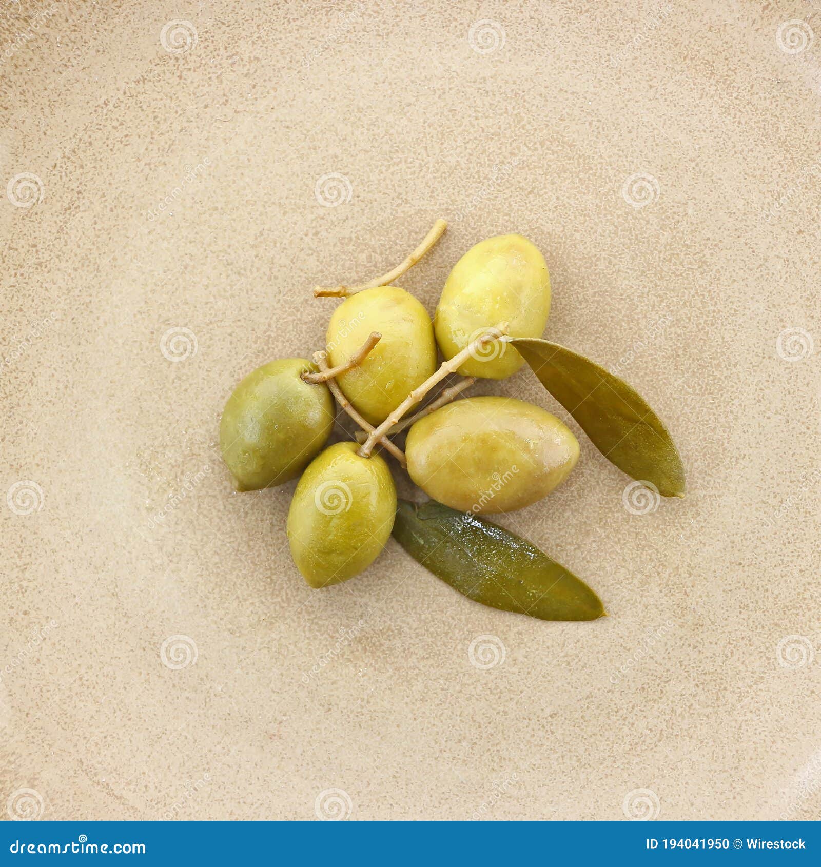 Closeup of Five Green Olives with Leaves on a Tan Background Stock ...