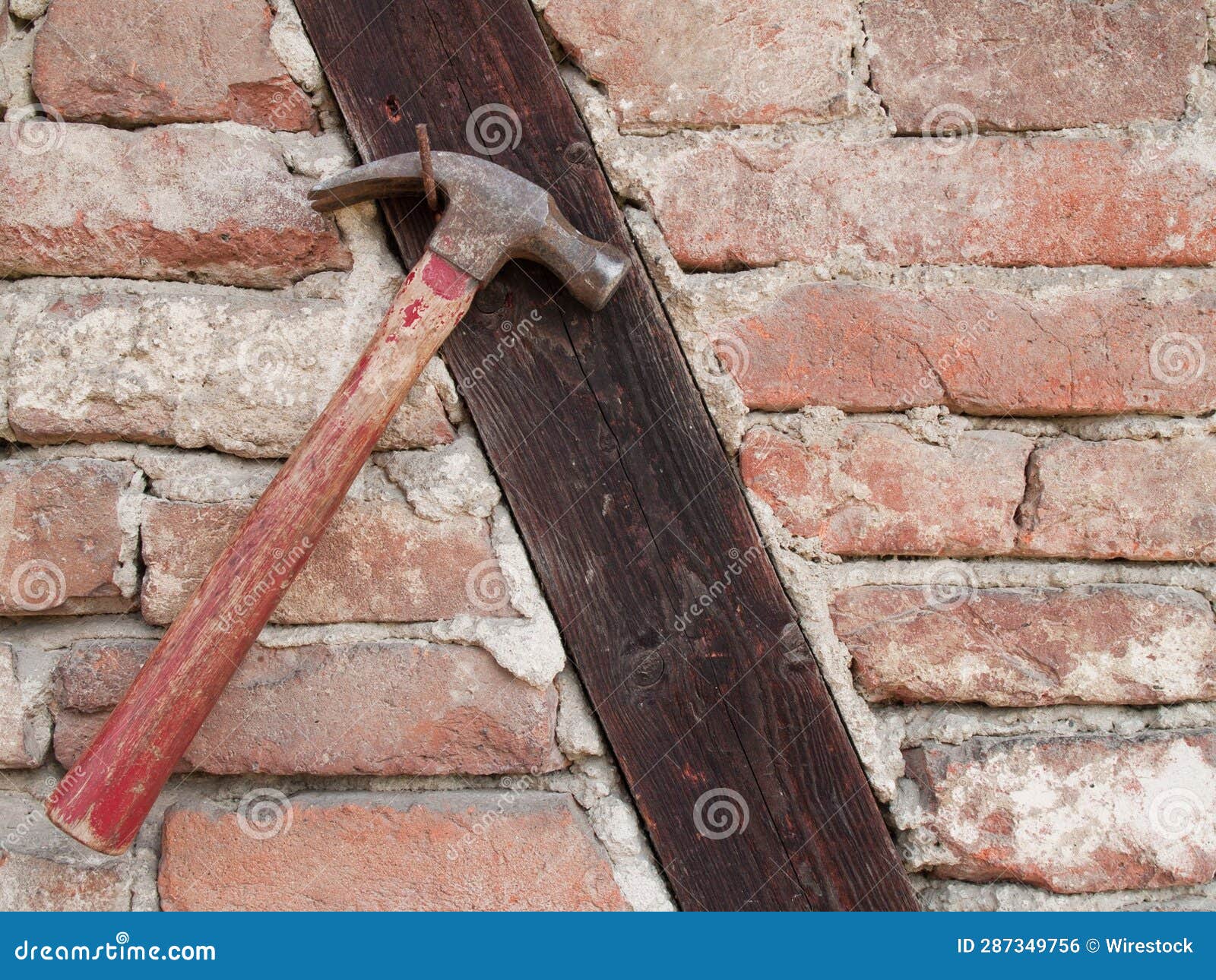 Closeup of a Hammer Hanging from a Nail on a Stone Wall Under the ...