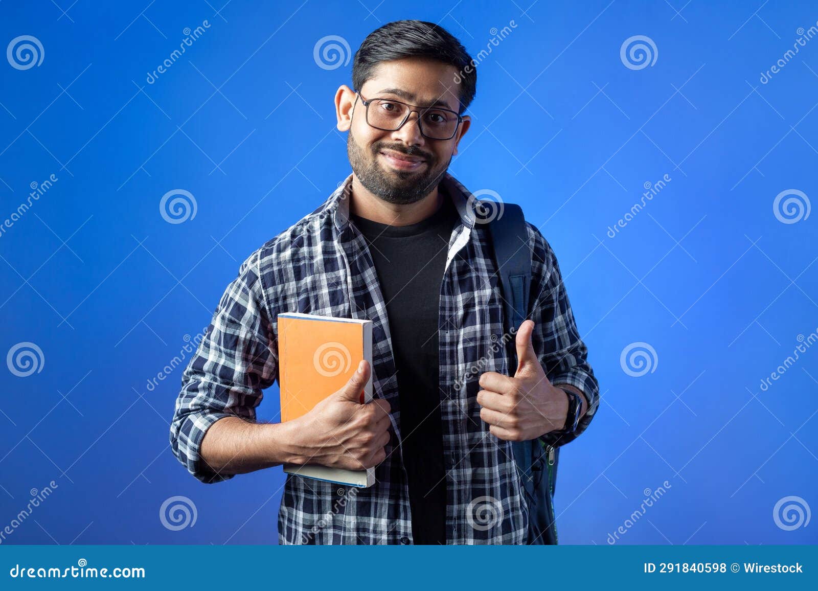 Closeup of a Handsome Student Holding a Book with a Blue Background ...