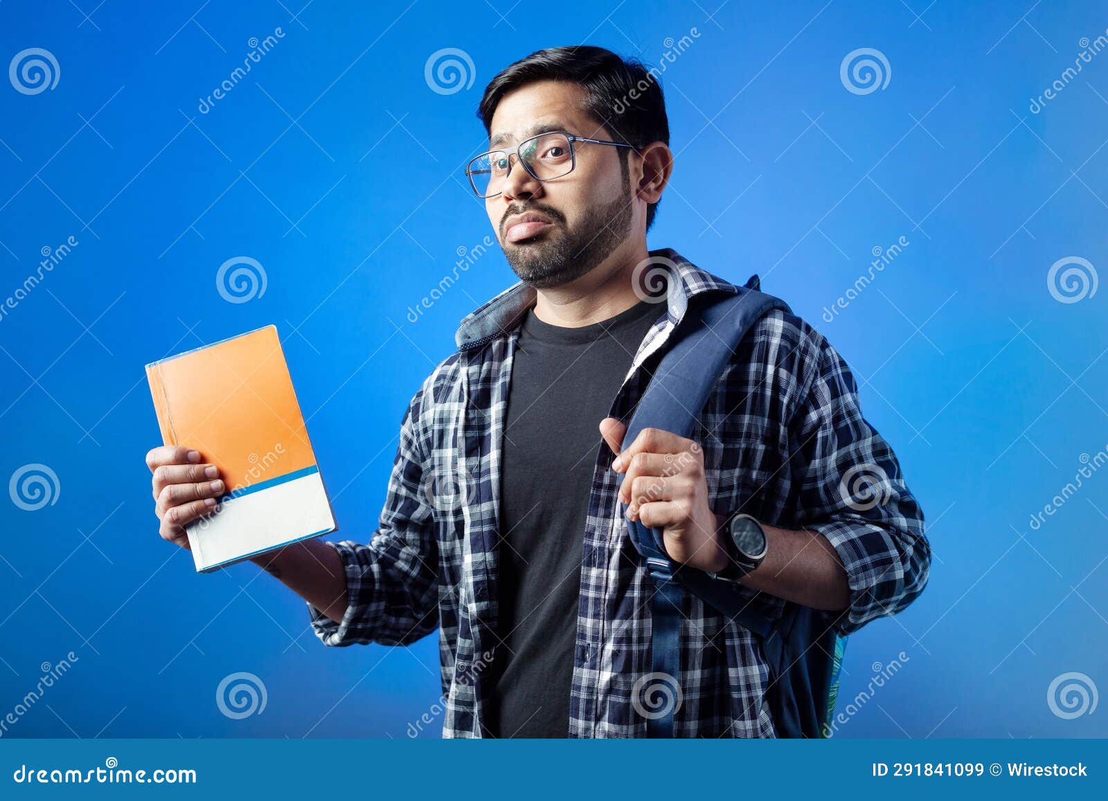 Closeup of a Handsome Student Holding a Book with a Blue Background ...