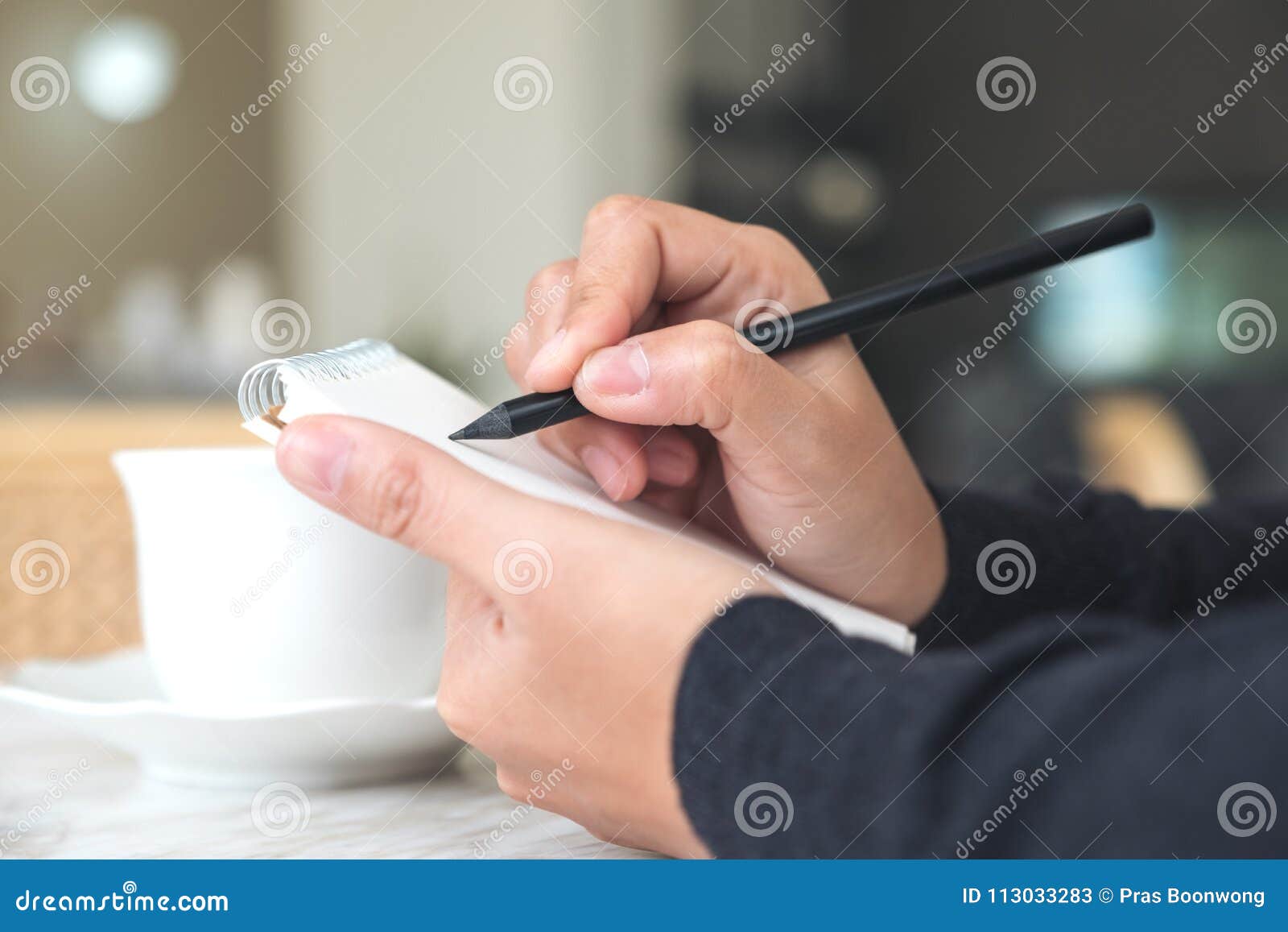 A Hand Writing Down on a White Blank Notebook with Coffee Cup and ...