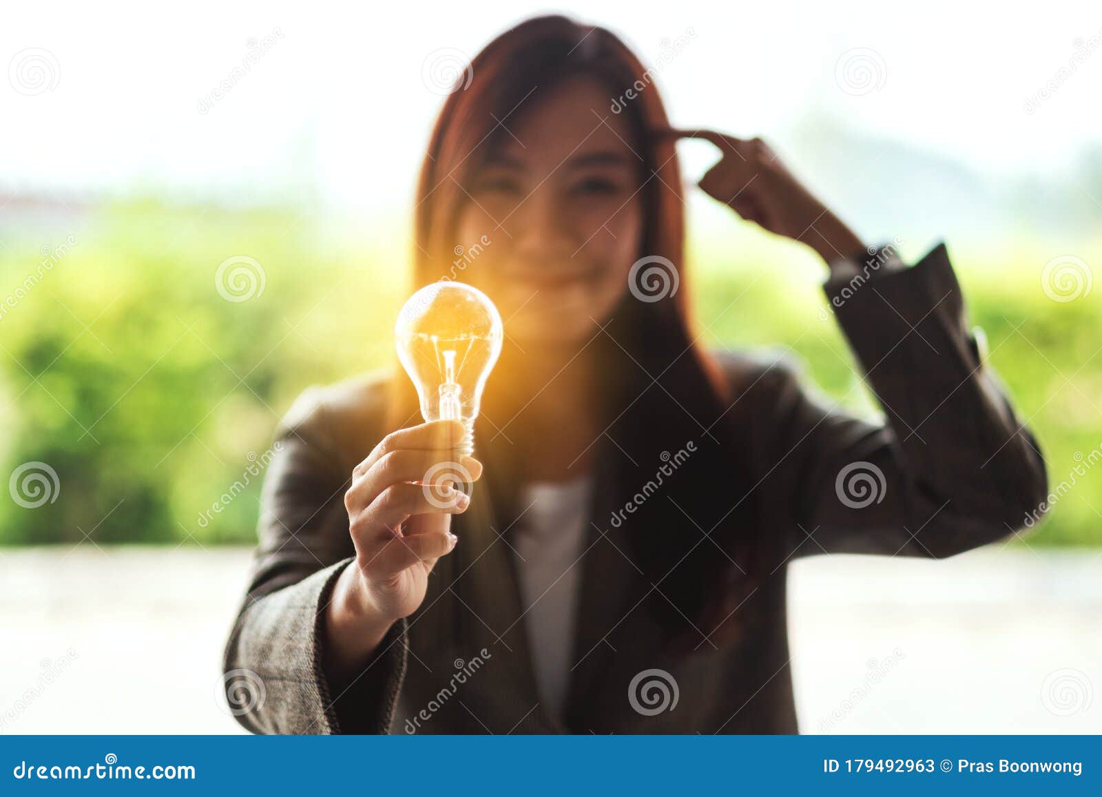 A Thinking Woman Holding and Showing Glowing Light Bulb Stock Image ...