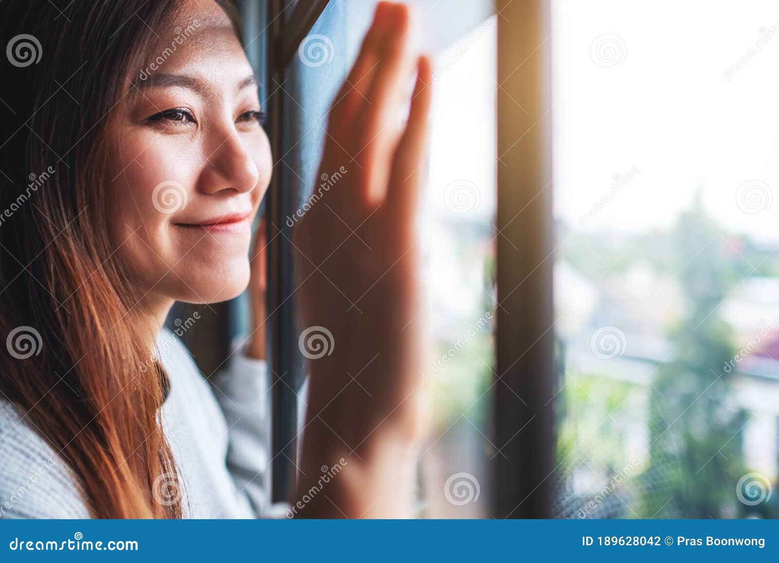 A Young Woman Touching on Window while Looking Outside Stock Photo ...