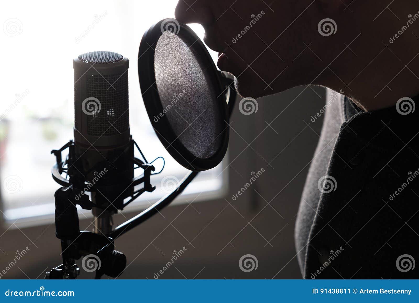 A Closeup of Lips at the Microphone of a Young Man Standing in Profile ...
