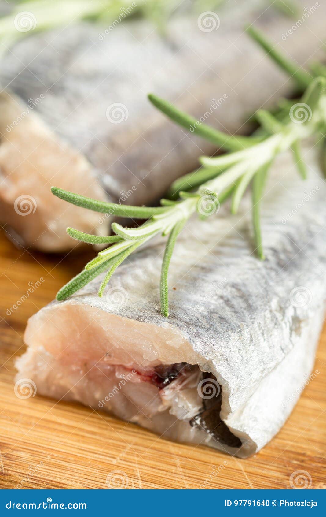 Closeup Macro Fresh Raw Hake Fish with Rosemary Branches on the Wooden ...