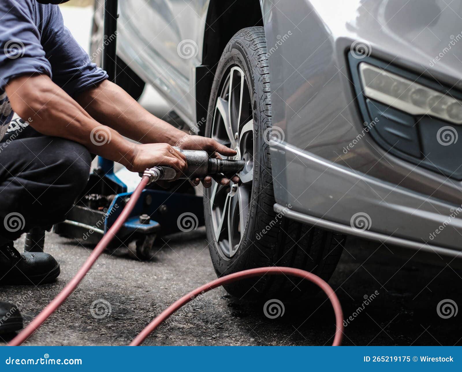 Closeup of a Man Fixing His Car Tire with a Tool Stock Image - Image of ...