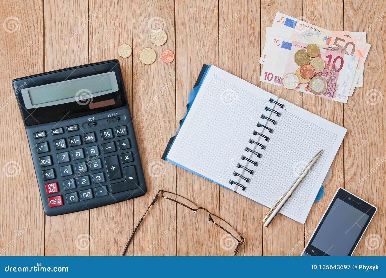 Closeup Open Notebook, Calculator, Pen, Smartphone on a Wooden Table ... Closeup Open Notebook, Calculator, Pen, Smartphone on a Wooden Table ...