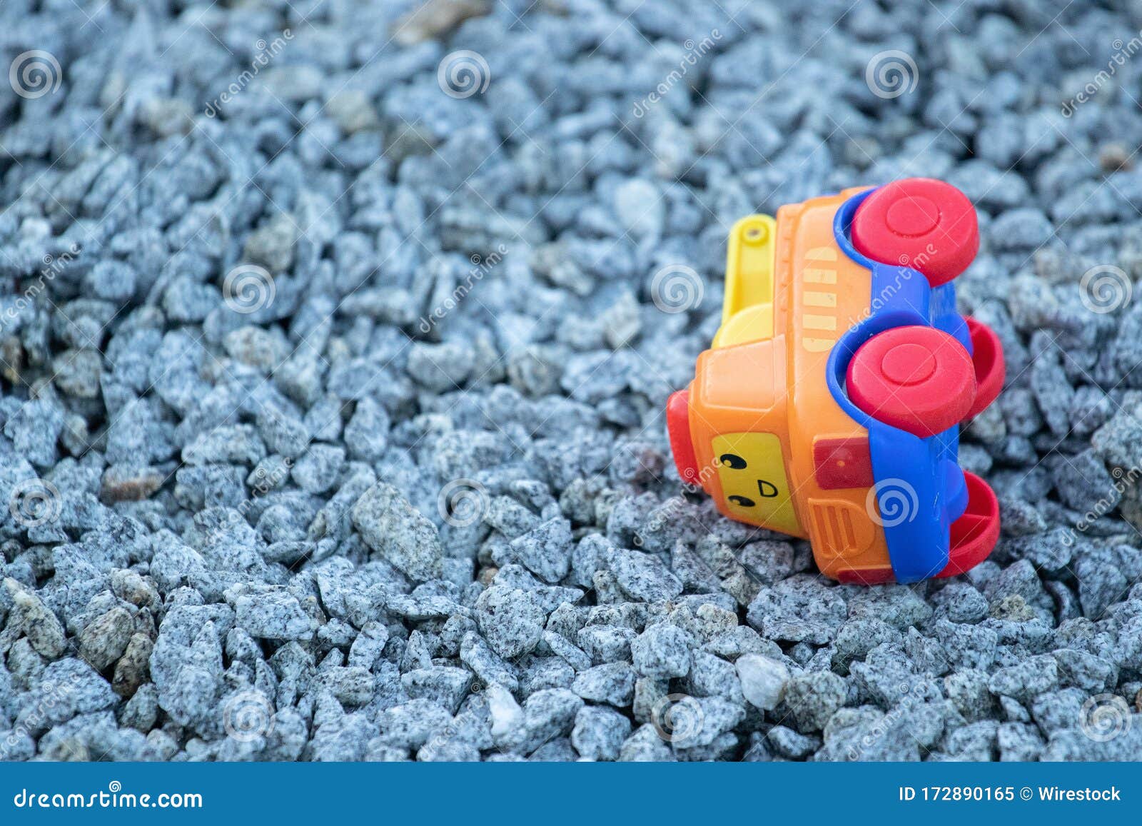 Closeup of a Plastic Toy Car on the Ground Covered in Small Rocks Under ...
