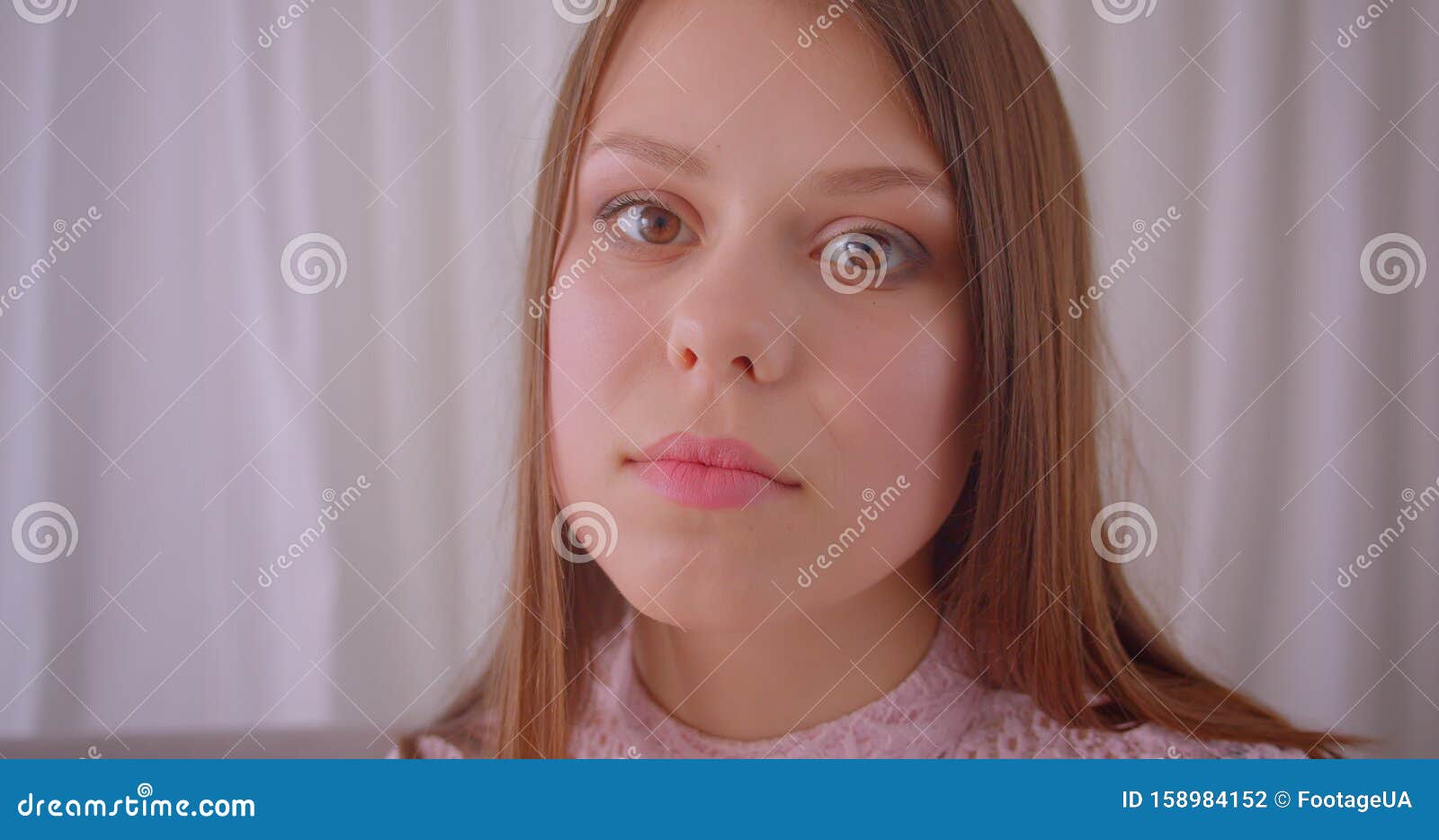Closeup Portrait Of Young Cute Caucasian Girl Looking At Camera Indoors