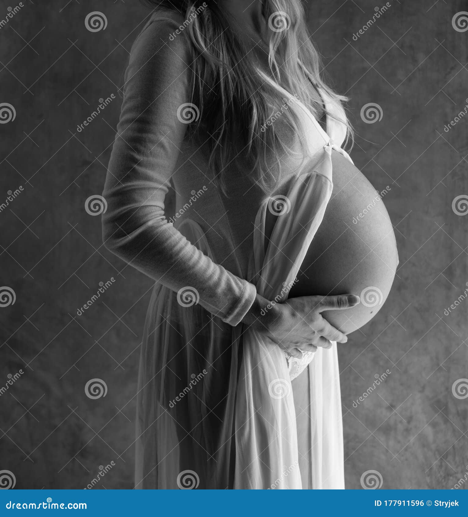 Closeup Pregnant Woman Touching Her Belly While Standing Over Gray Wall