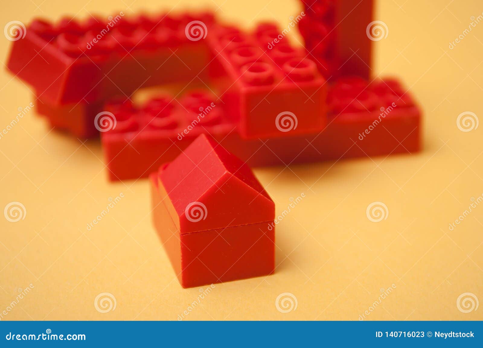 Red Plastic Bricks Construction on Yellow Background Stock Image ...