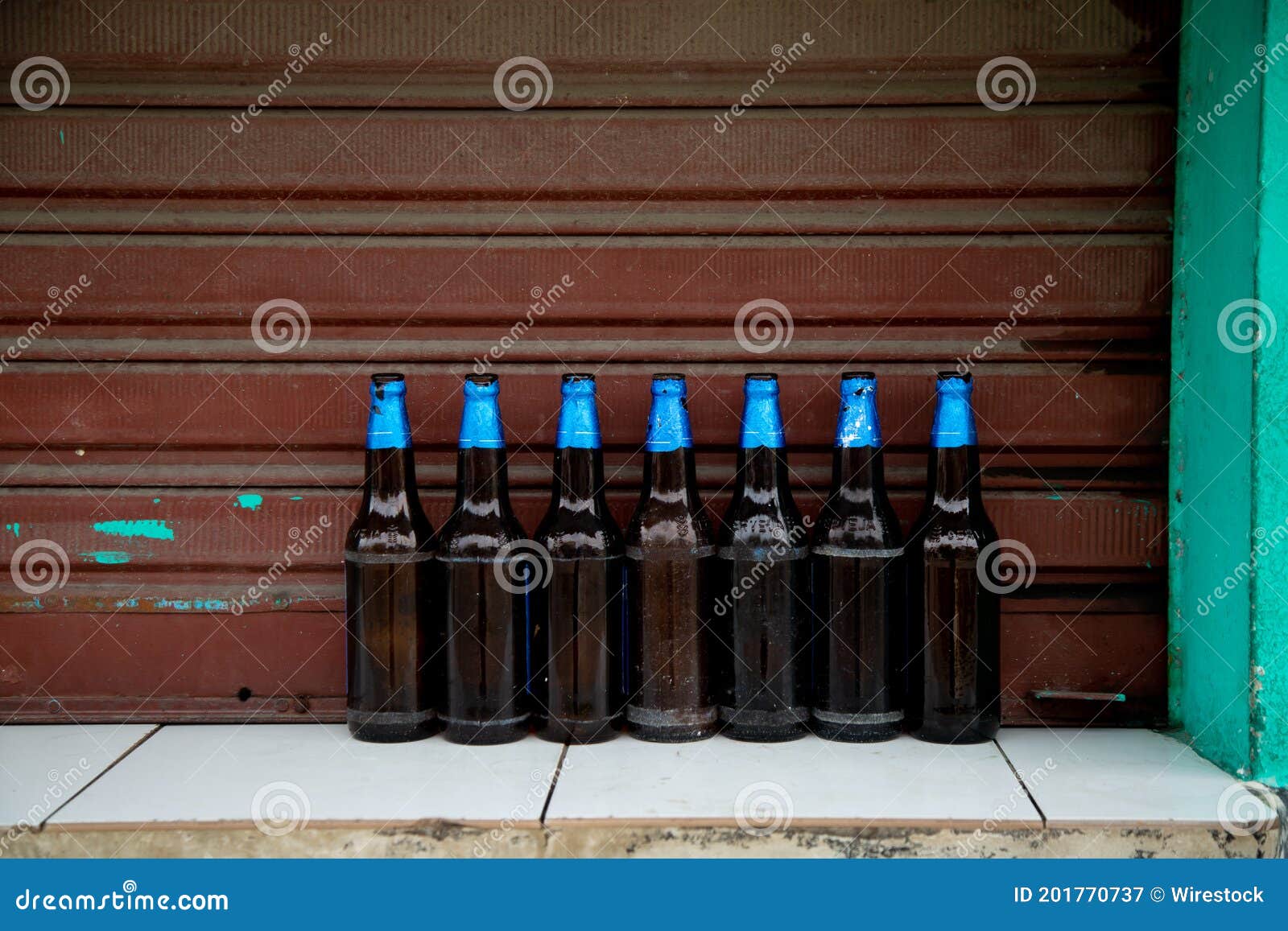 Closeup of a Row of Empty Ember Bottles with Blue Paint on the Neck ...