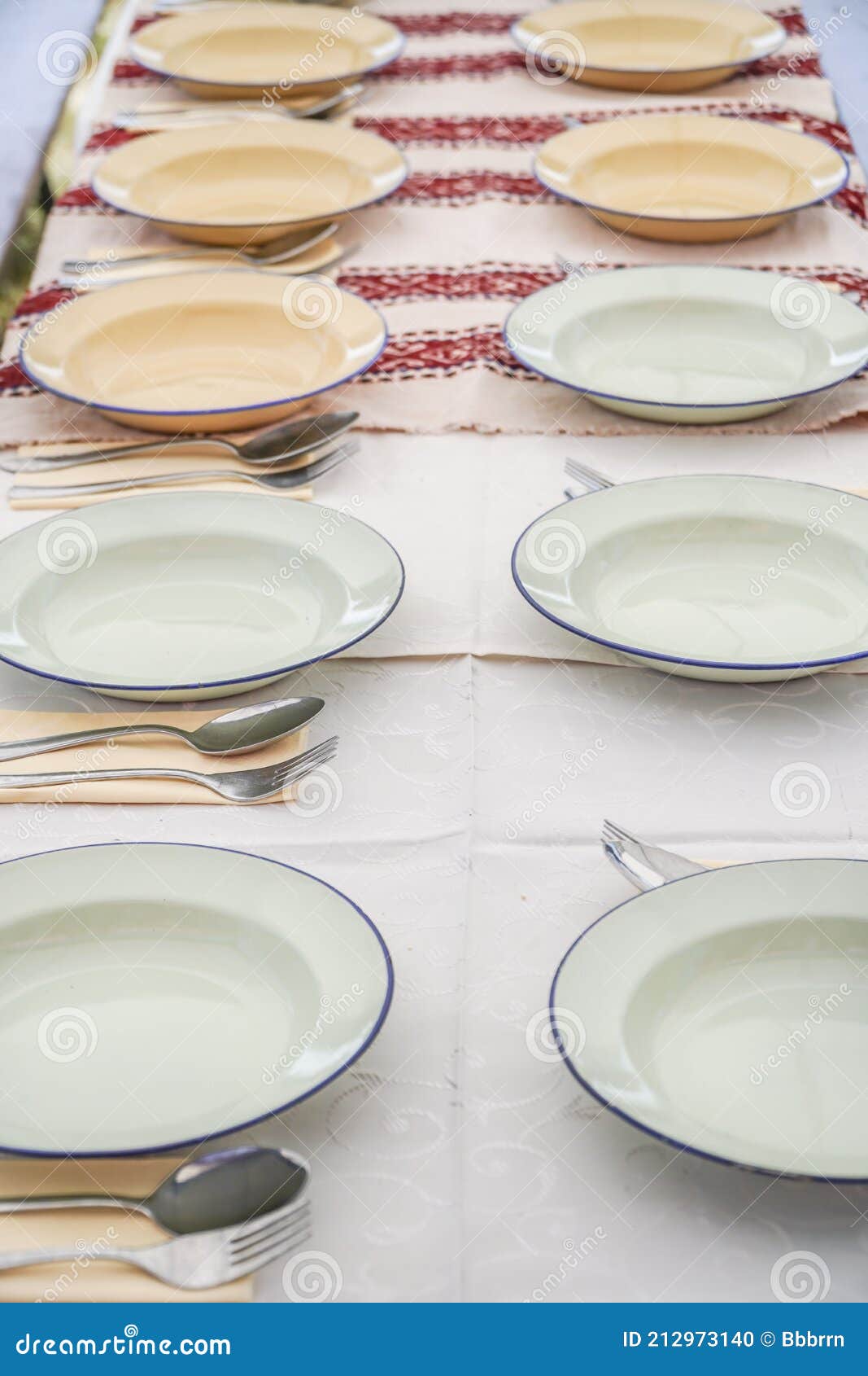 Row of Empty Enamel Plates on the Table Set for Dinner Stock Photo ...