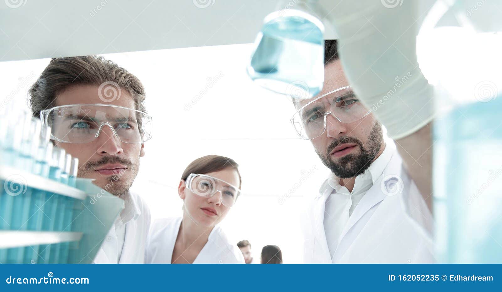 Closeup. Scientist and Assistant Studying the Solution in the Glass ...