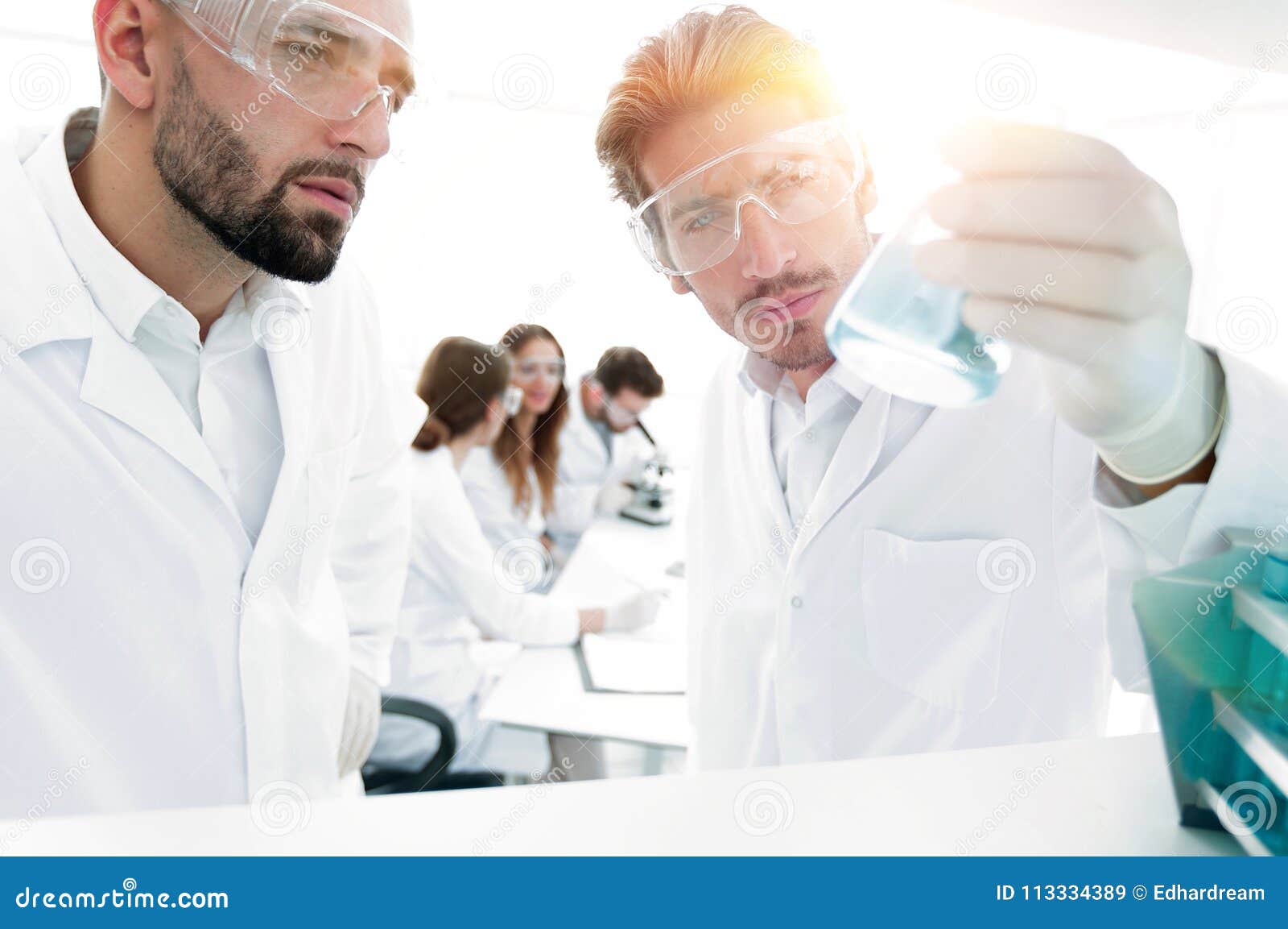 Closeup. Scientist and Assistant Studying the Solution in the Glass ...