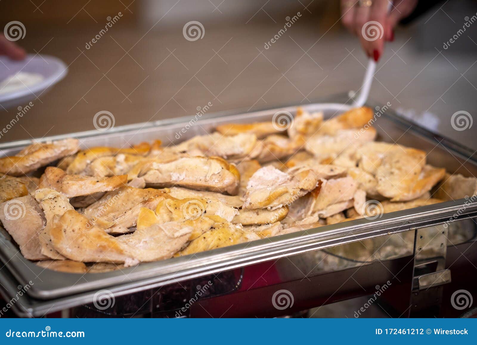 Closeup Shot of Cooked Meat Piled in a Chafing Dish Being Served from a ...