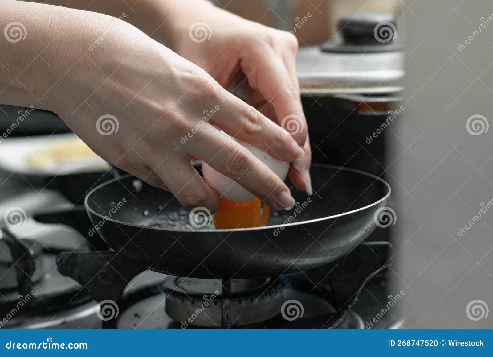 Closeup Shot of Female Hands Cracking Open an Egg into a Metal Pan ...