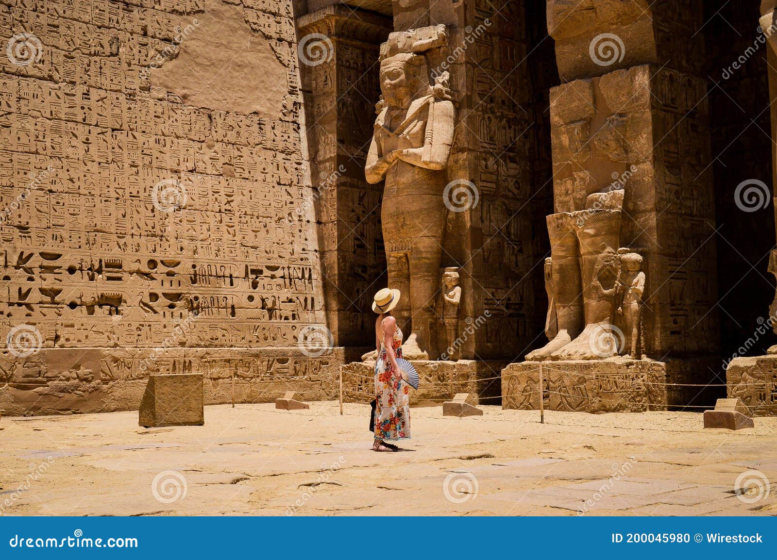 Closeup Shot of a Female Standing in Front of a Medinet Habu Temple in ...