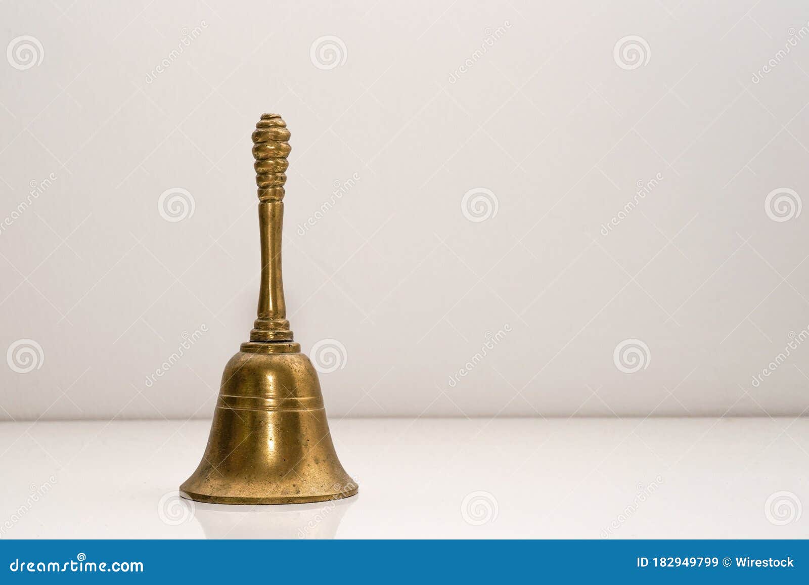 Closeup Shot of a Golden Handbell on a White Wall Background Stock ...