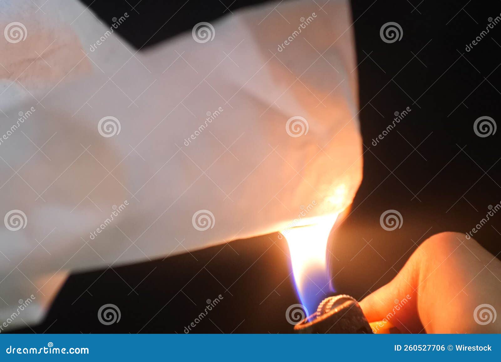 Closeup Shot of a Hand Burning a Paper with Fire Flames in a Blurred ...