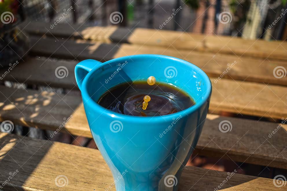 Closeup Shot of Milk Drops Falling in a Cup of Coffee on the Table ...