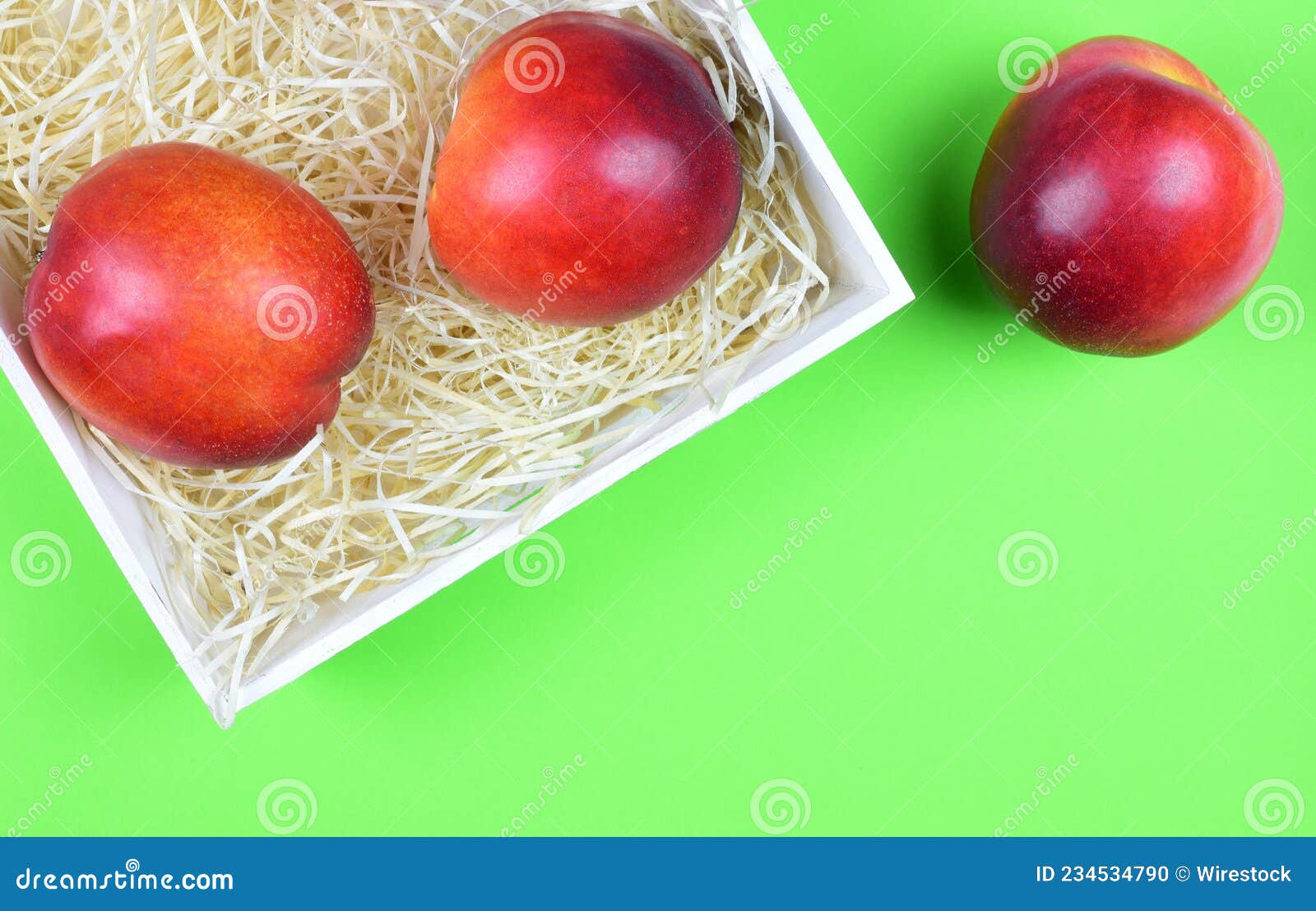 Closeup Shot of Nectarines in a Box with Straw on a Green Background ...