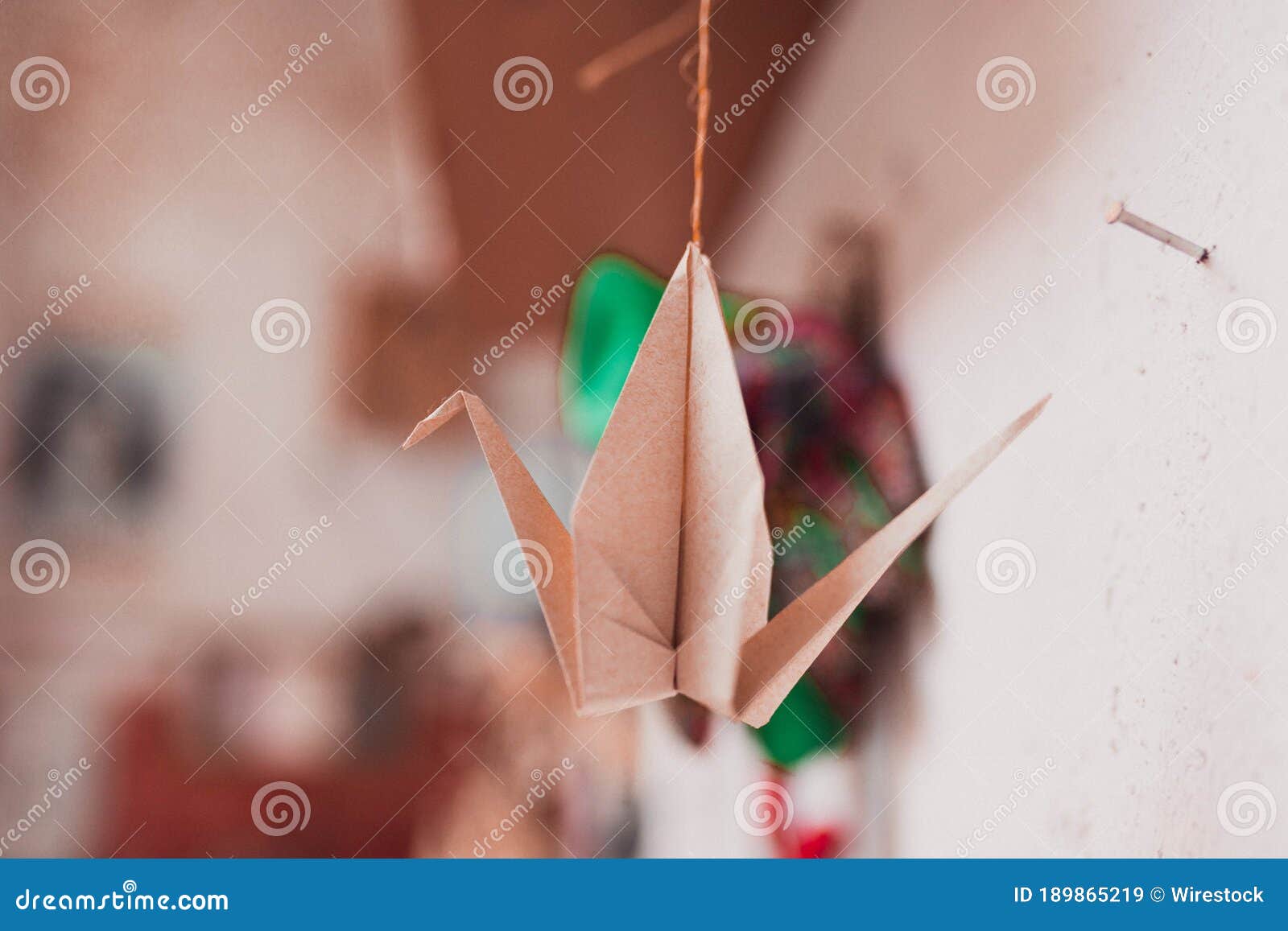 Closeup Shot of Origami Paper Crane Hanging from a String on a Blurred ...