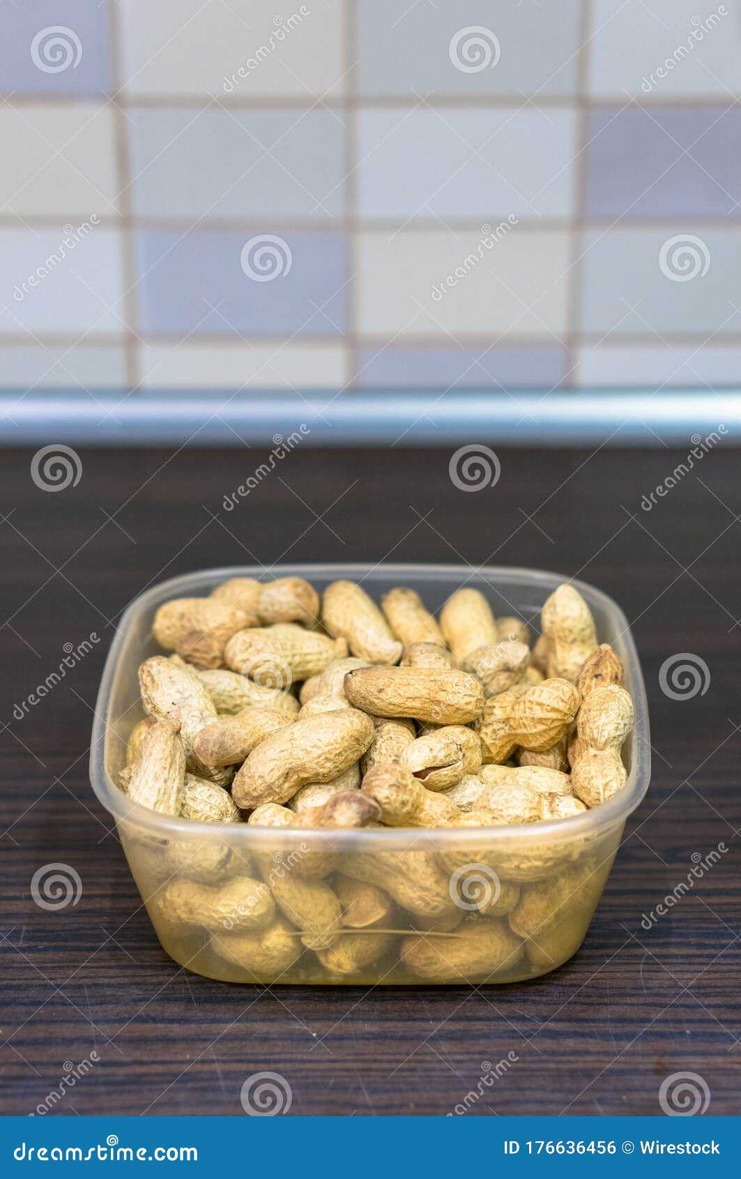 Closeup Shot of Roasted Peanuts in a Plastic Container on a Wooden ...