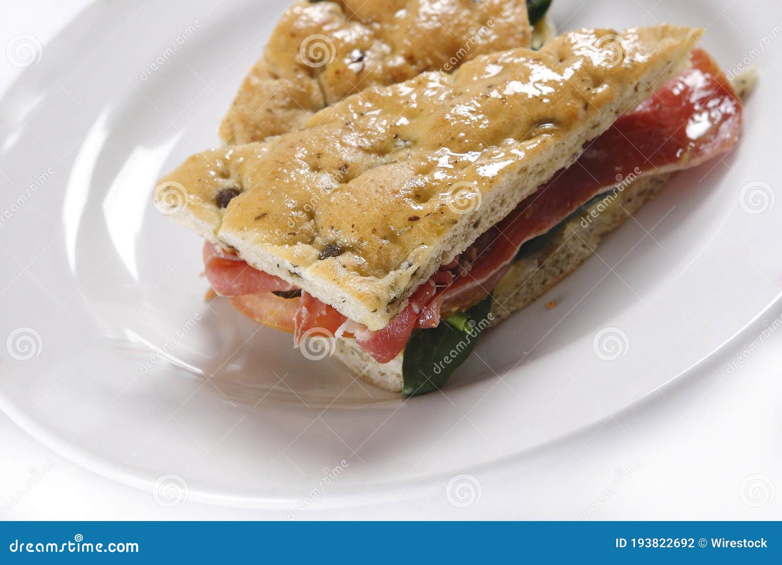 Closeup Shot of Triangle Bread Sandwich with Serrano Ham, Spinach, and ...