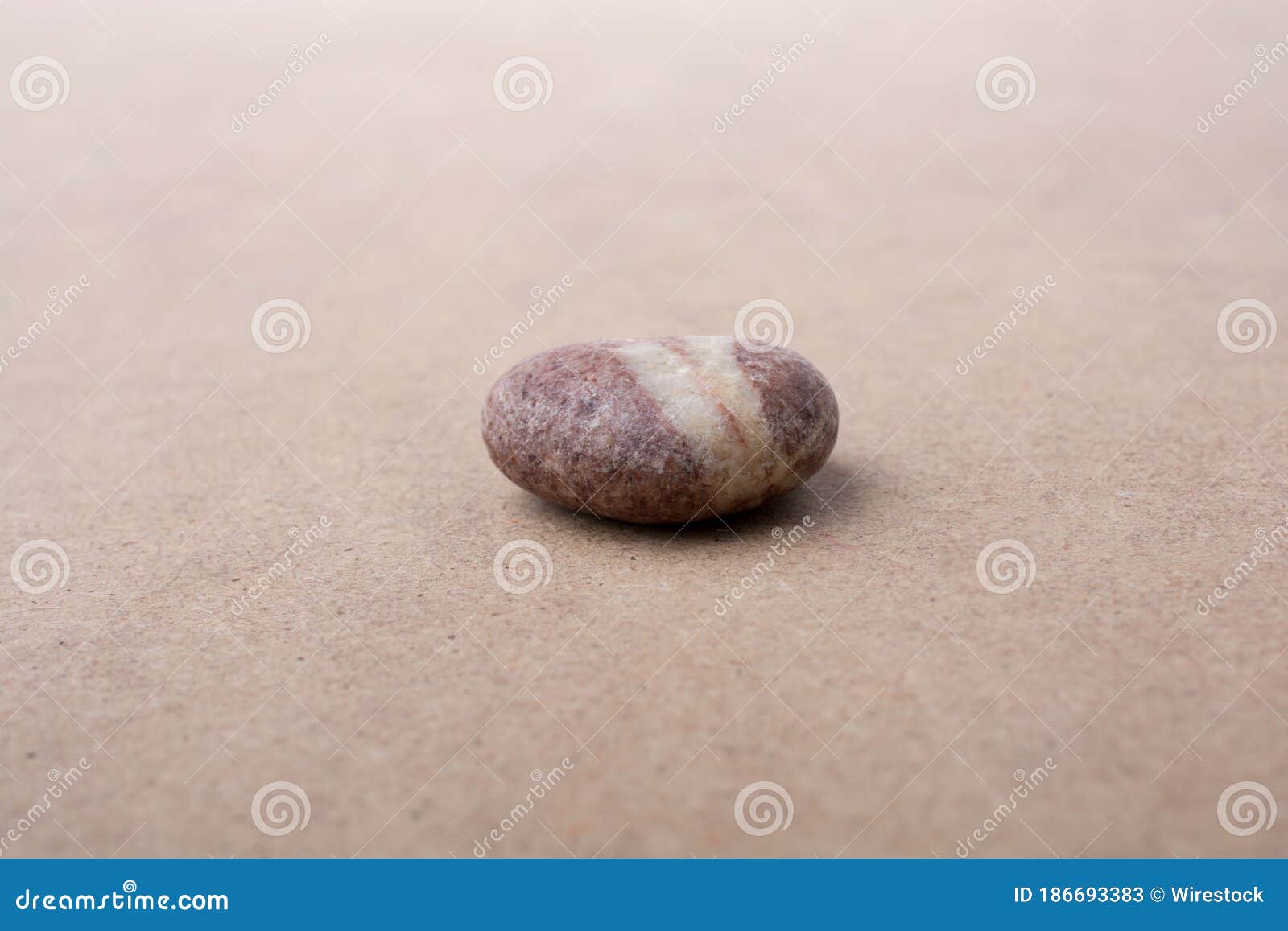 Closeup of a Single Pebble Stone Isolated on a Beige Background Stock ...