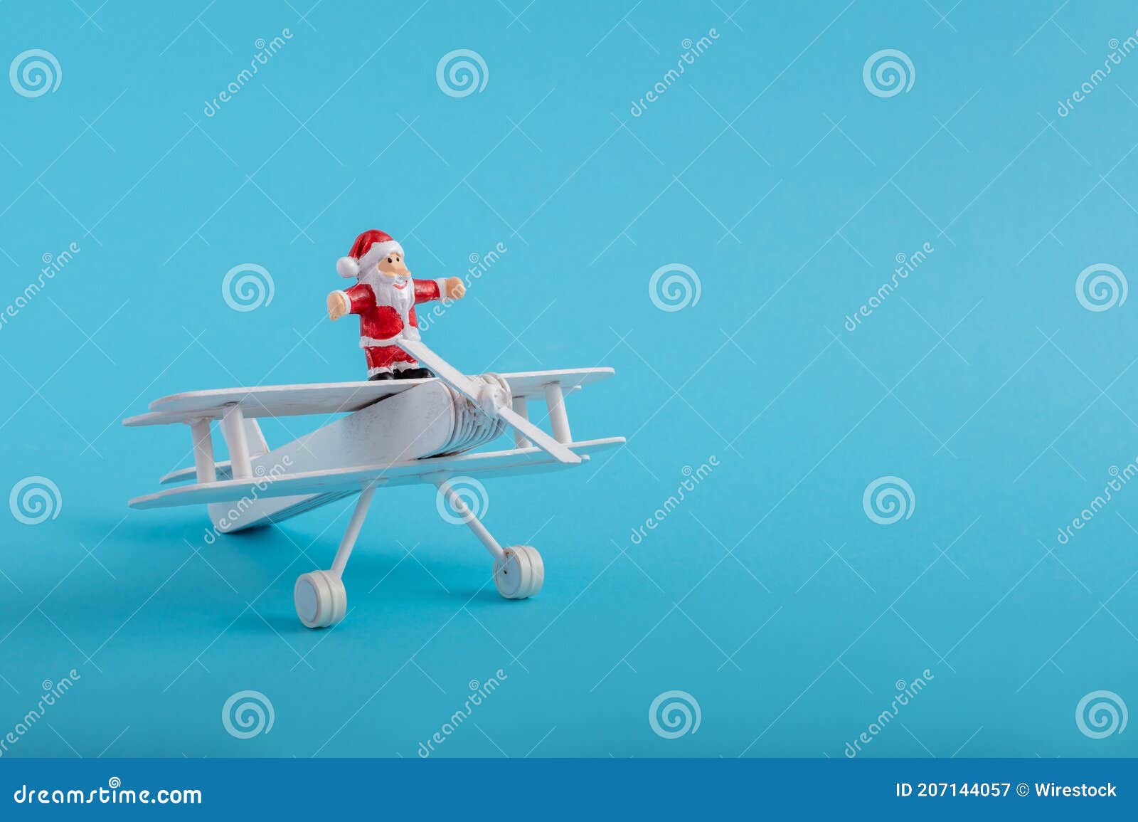 Closeup of a Small Santa Standing on an Airplane on a Blue Background ...