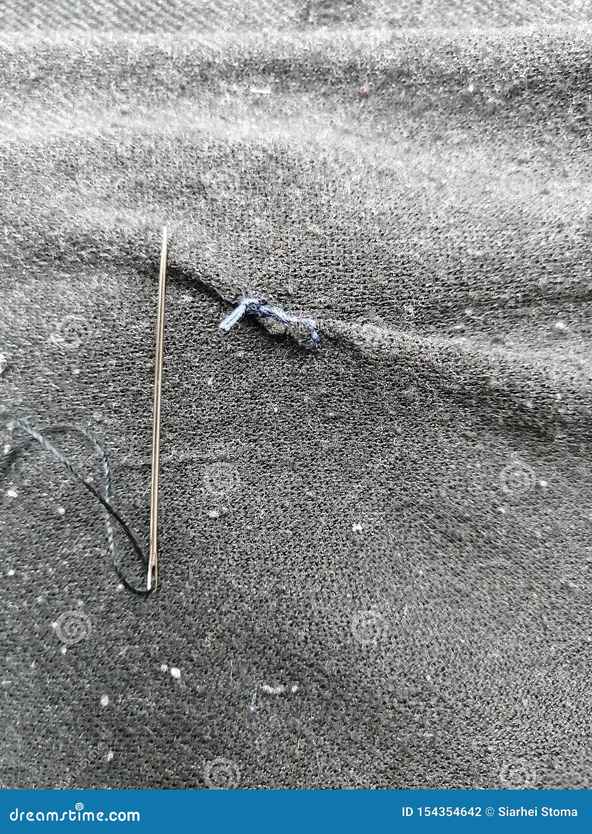 Sewing Needle with Black Thread on a Gray Fabric Stock Photo - Image of ...