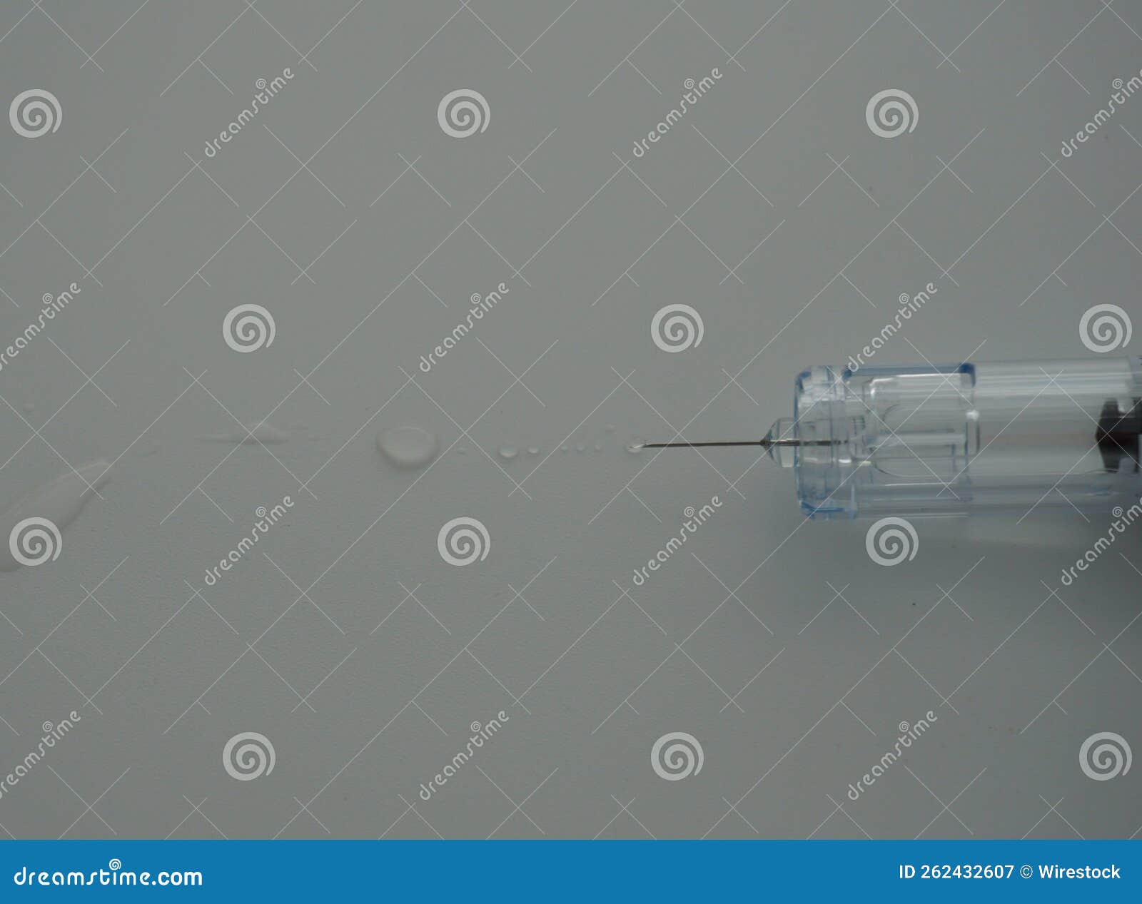 Closeup of a Syringe Filled with a Liquid with Drops at the End of the ...