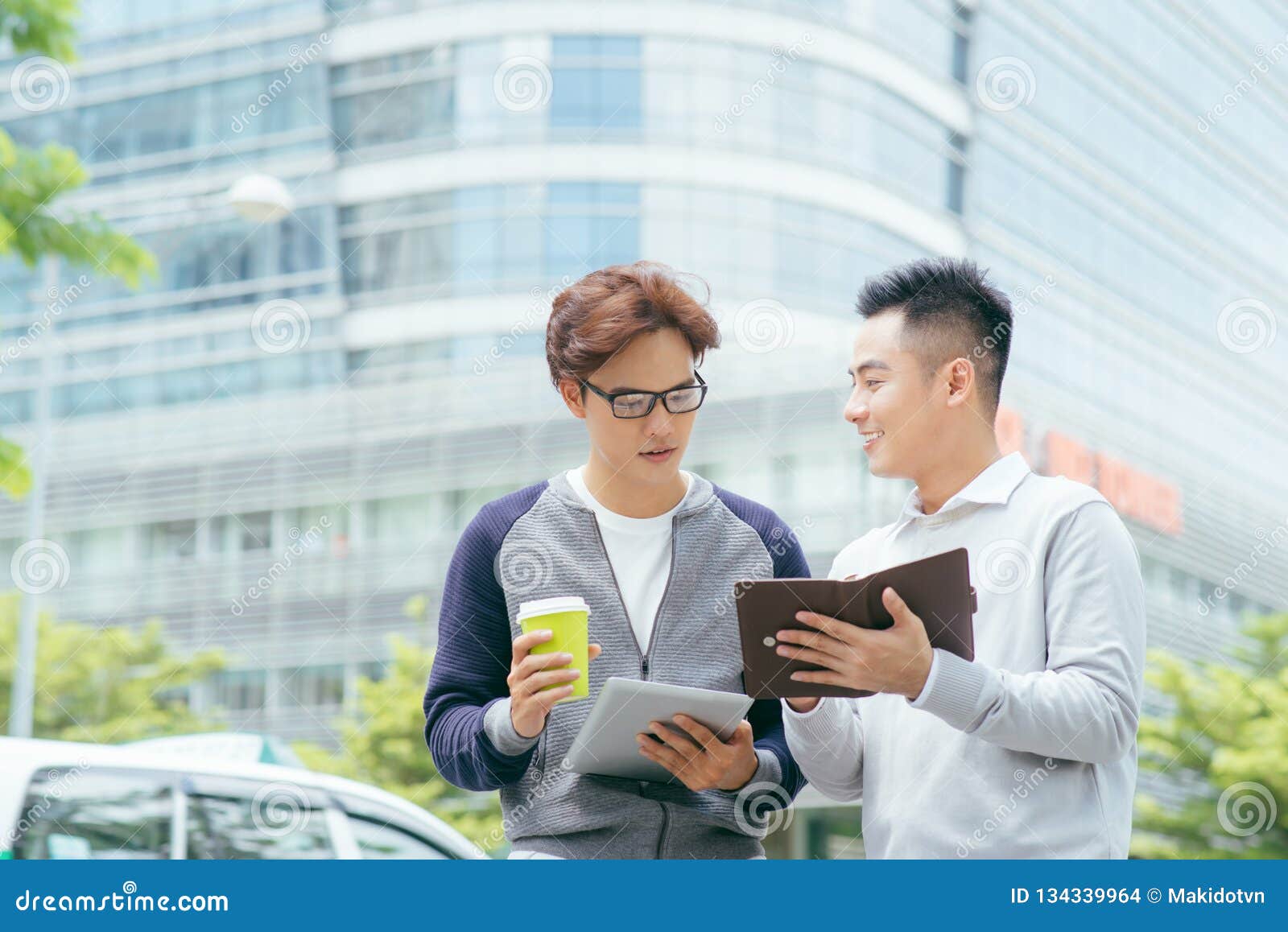 Closeup of Two Smiling Business Men Using Tablet Computer and Walking ...